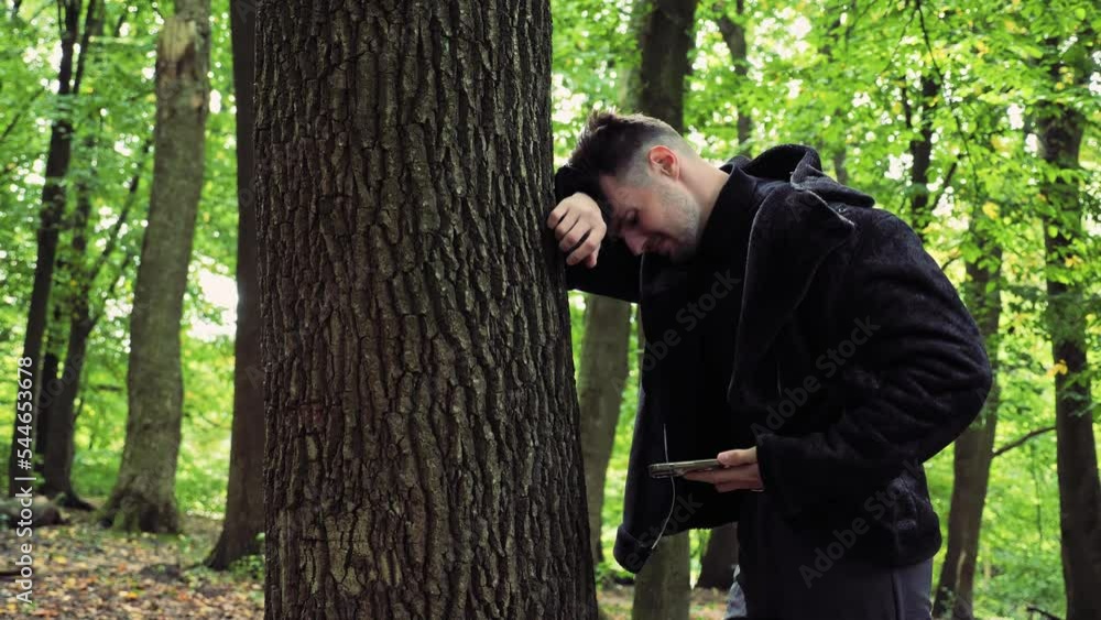 Frustrated male face of sad stressed man standing near tree in the ...