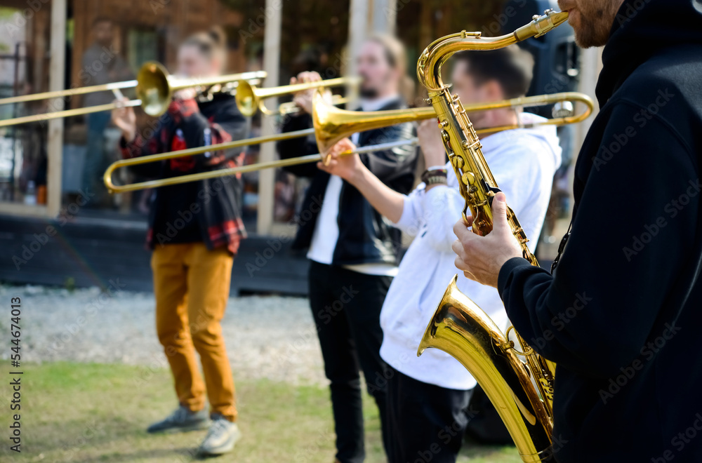 Male musician in a white shirt with a saxophone playing in a jazz band ...