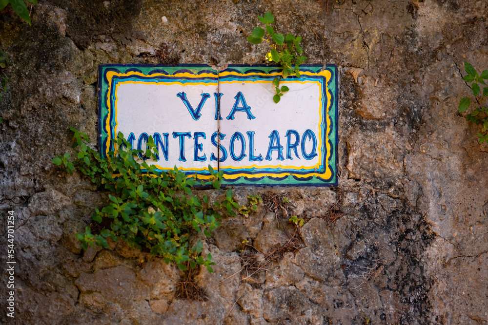 Historic street sign „Mount Solaro Str“ on an old overgrown town wall ...