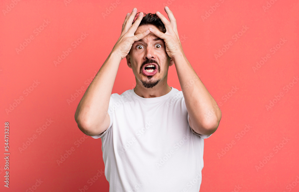 feeling horrified and shocked, raising hands to head and panicking at a ...