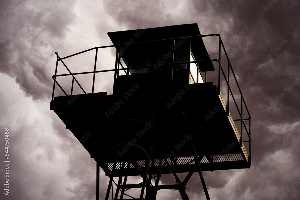 Dark silhouette of the metal structure of the watchtower, clouds in the ...