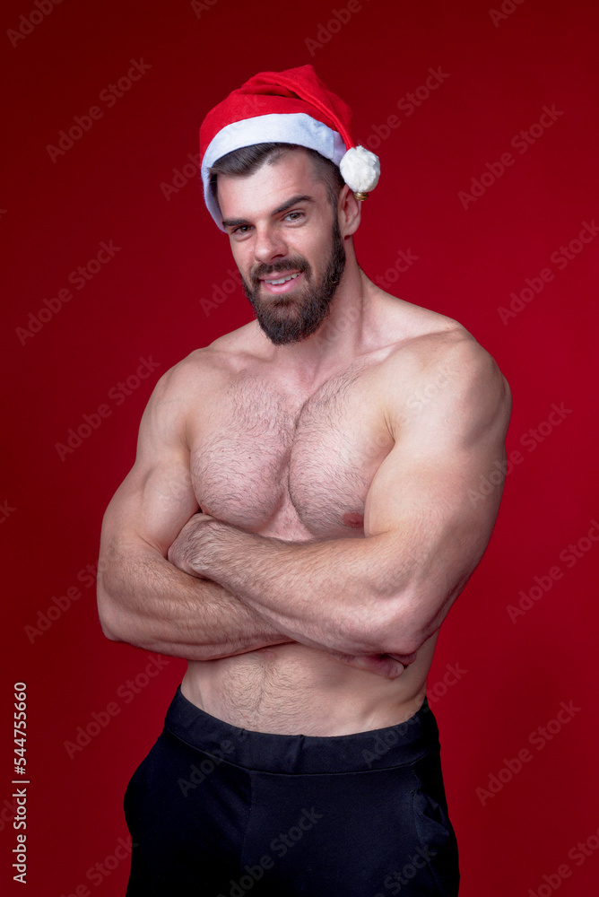 Sexy santa, young shirtless bodybuilder wearing a christmas hat ...