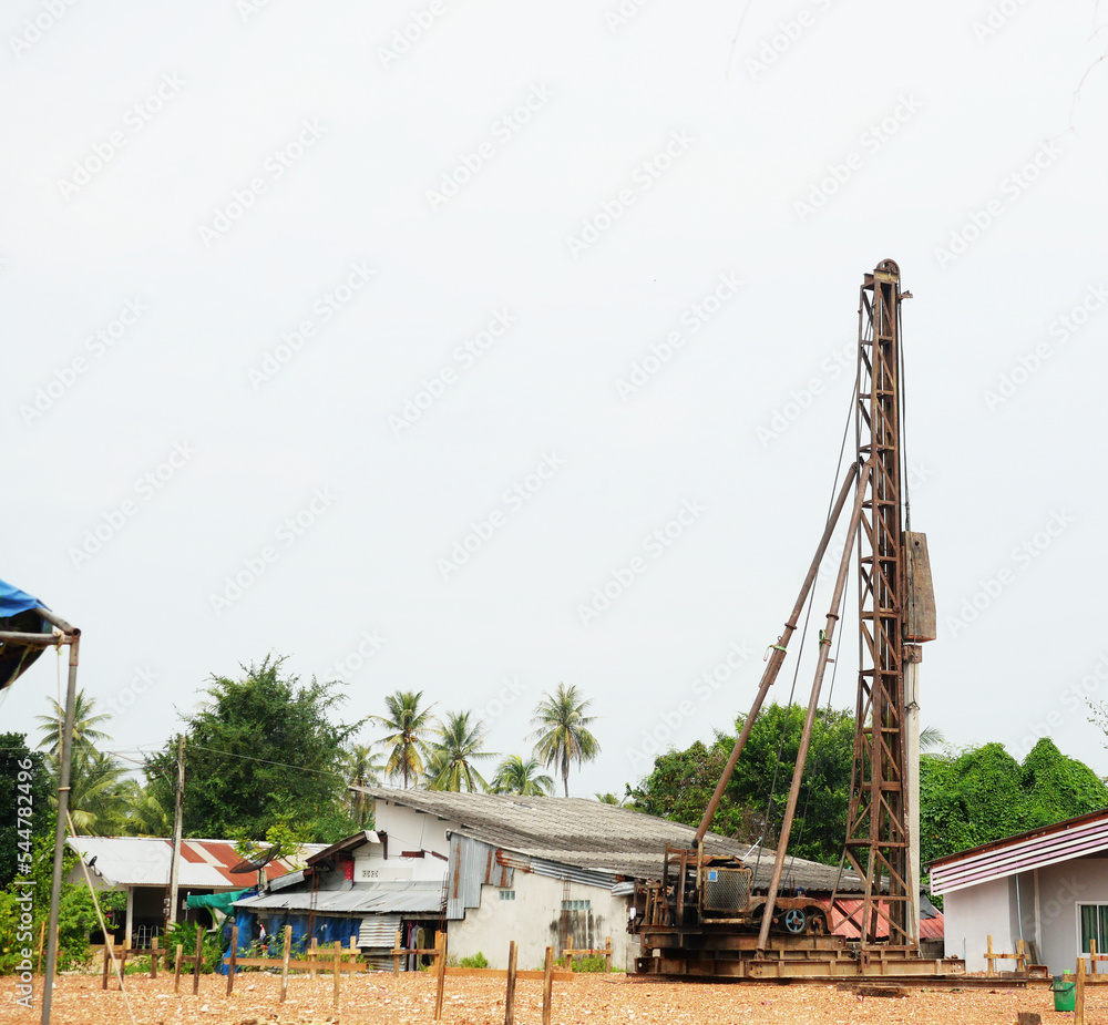 Concrete pile is being driven into the ground at construction site ...