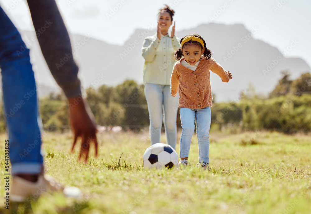 Parents, park and girl kick soccer ball for fun sports learning, bonding and relax in sunshine ...