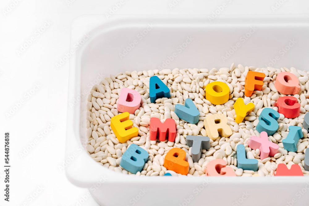 Colorful letters of the alphabet in sensory bin. Primary school or ...