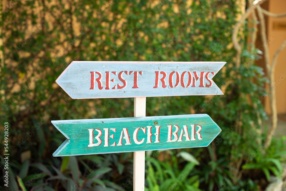 Close up of painted wooden signs in a resort hotel. Showing rest rooms ...