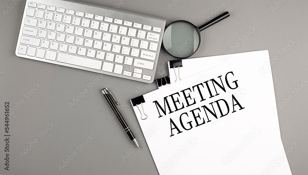 MEETING AGENDA text on paper with keyboard, magnifier and pen. Business ...