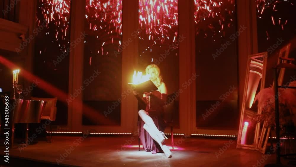 Beautiful woman in dress holds burning old book in her hands on dark ...