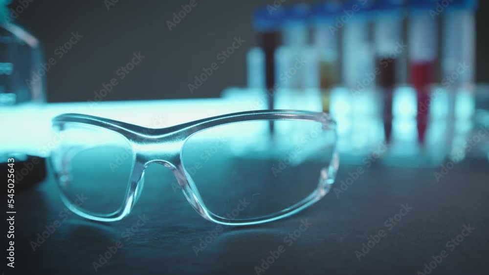 Laboratory workstation with glass safety goggles, measuring vessels and ...