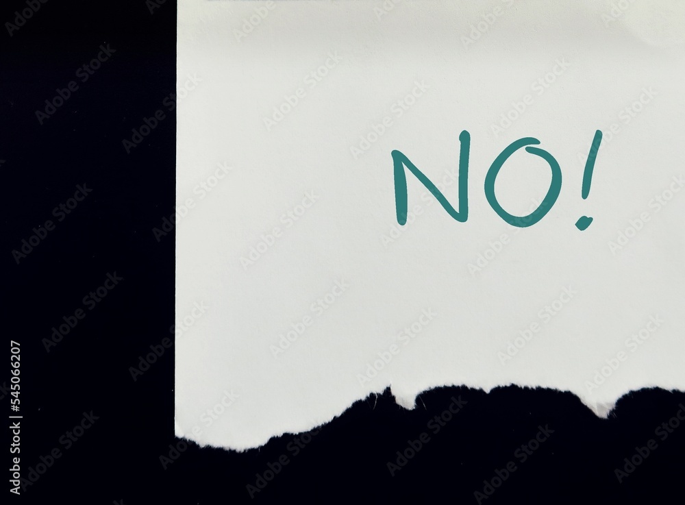 White paper stick on black background with handwritten text NO ...