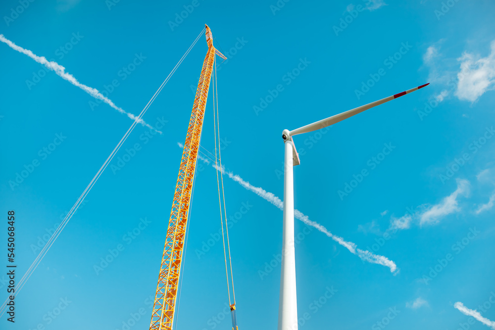 Construction work. Large wind power station nacelle on tower high up ...