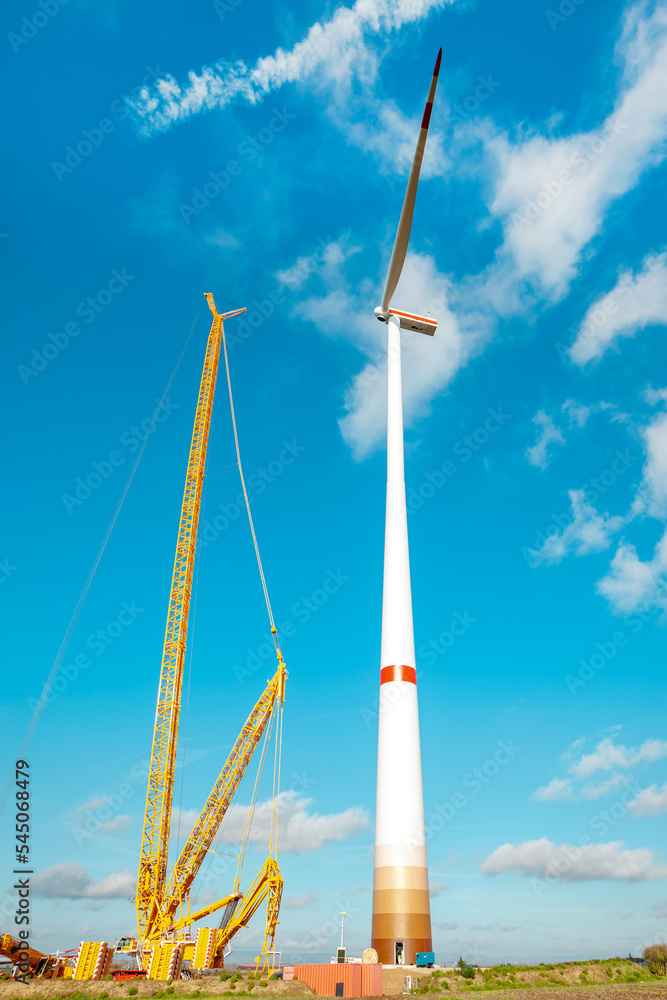Construction work. Large wind power station nacelle on tower high up ...