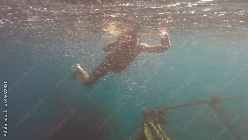 Man snorkeling exploring old shipwreck on bottom of sea. Happy traveler ...