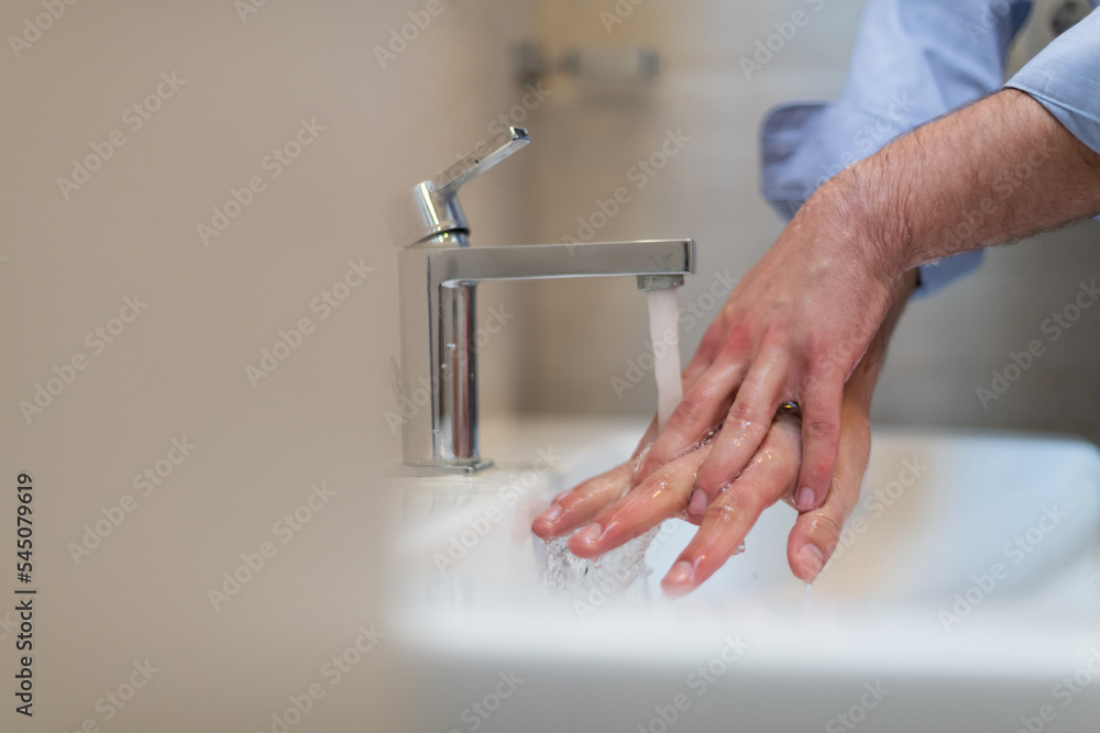 Man using soap and washing hands under the water tap. Hygiene concept ...