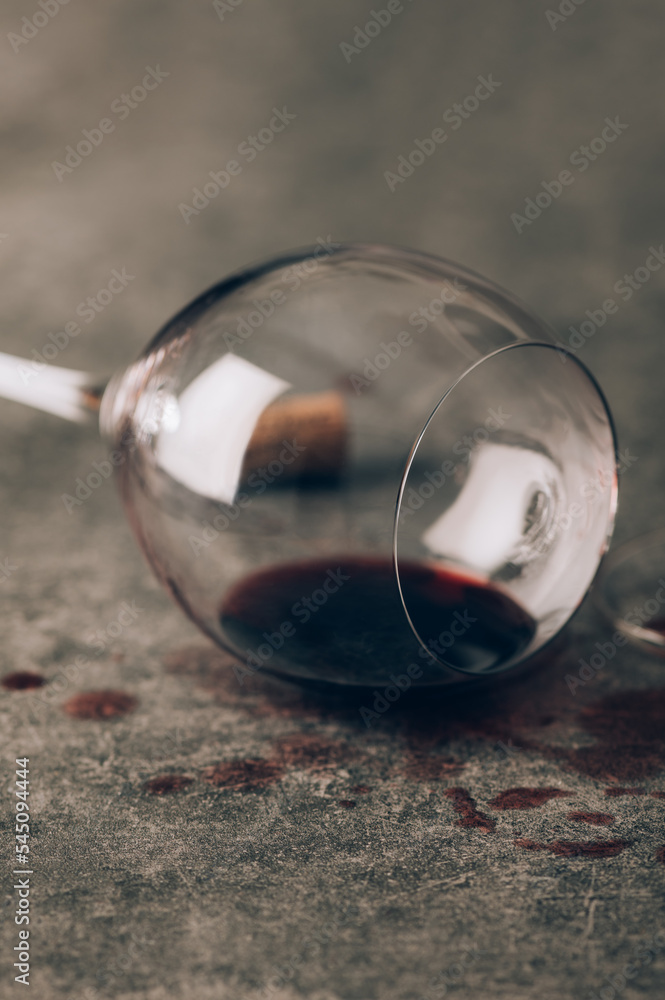 Red wine spilled from glass on ceramic floor, grey background, high ...