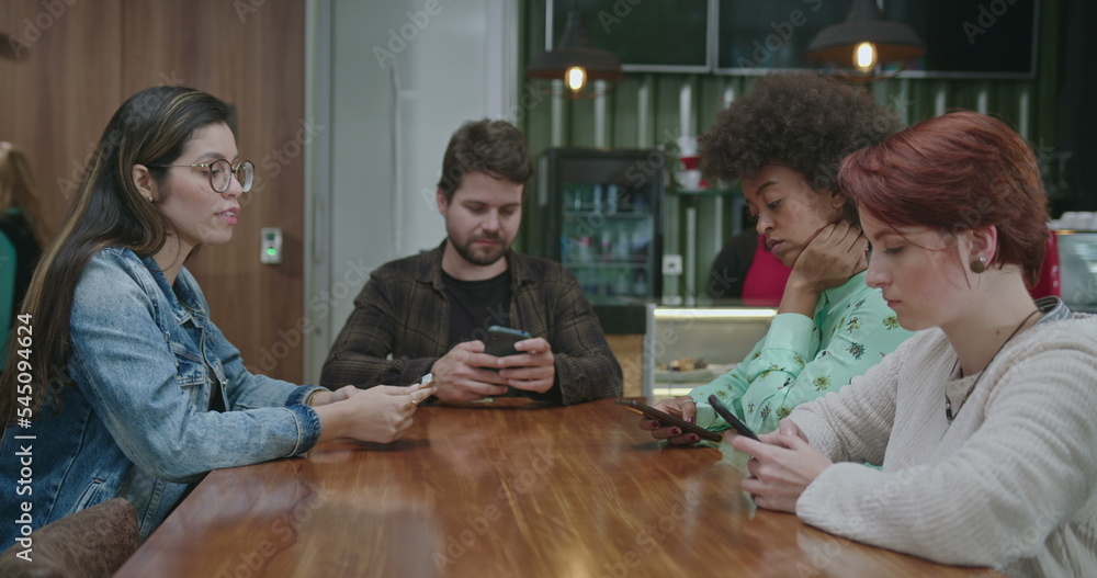 Group of students watching mobile phones at coffee shop. Young people ...
