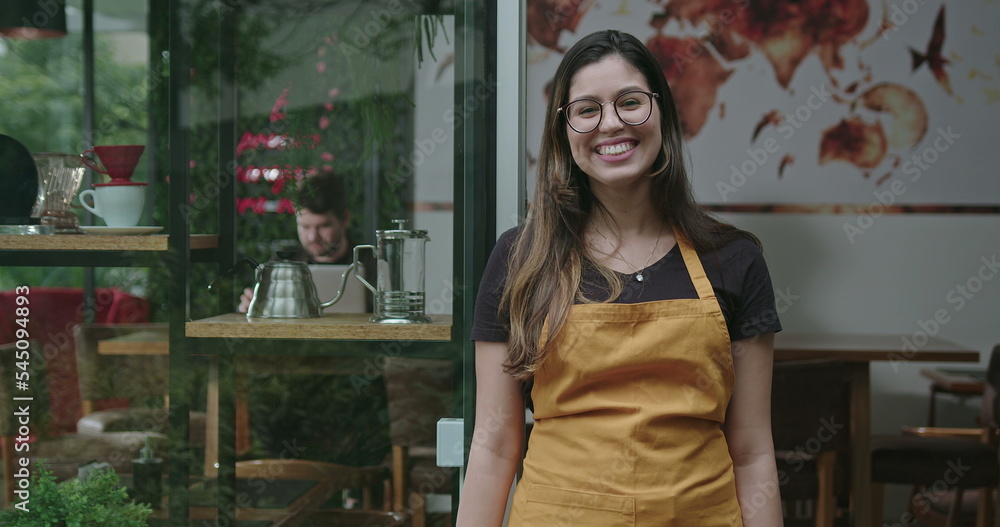 One happy female employee standing in front of small business coffee ...
