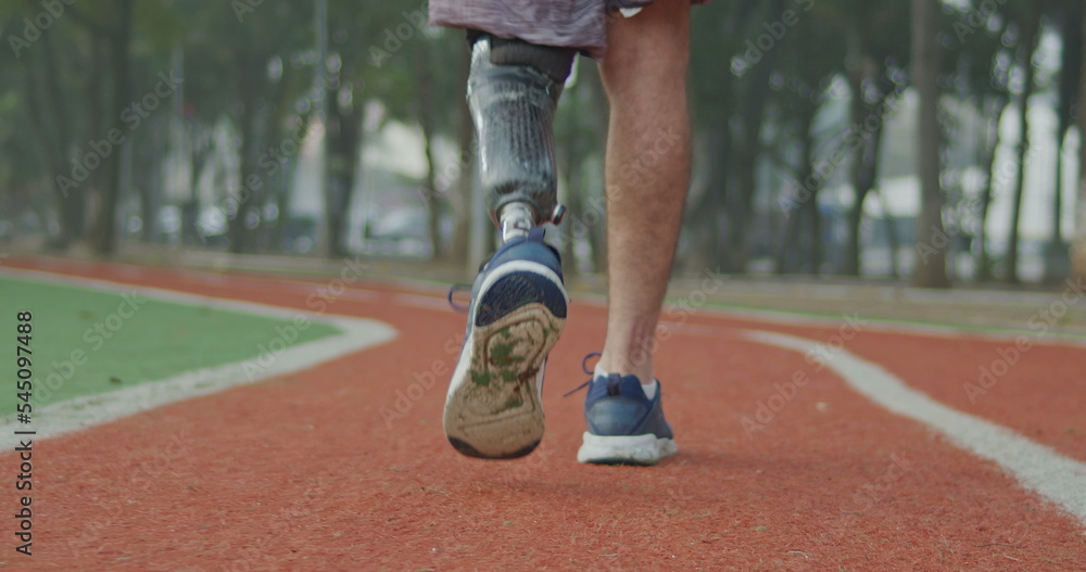 One disabled athlete walks outdoors with prosthetic leg. Male person ...