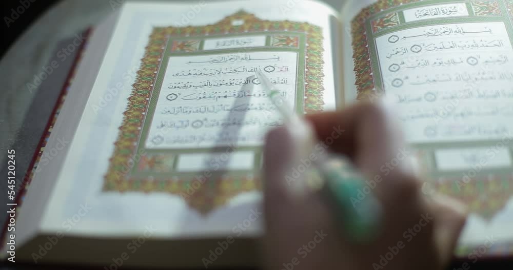 The holy Quran. Al Quran that is open and being read by a Muslim woman ...