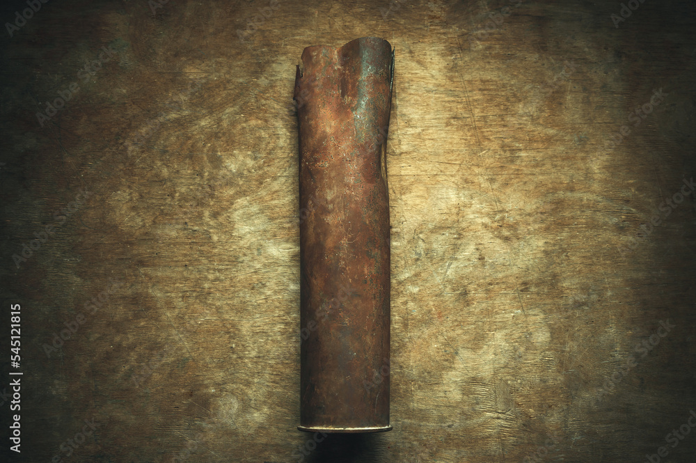 A large old shell casing from a tank on a wooden background.Artifacts ...
