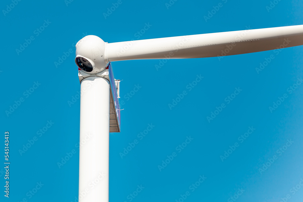 Construction work. Large wind power station nacelle on tower high up ...