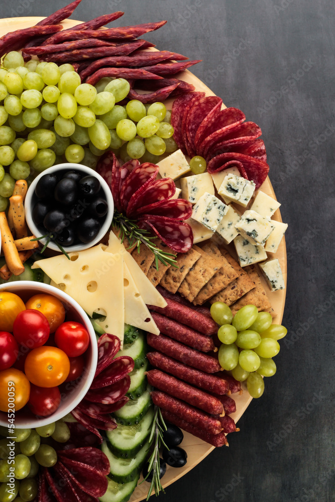 Gold meat plate, charcuterie on a dark background with copy space. The ...