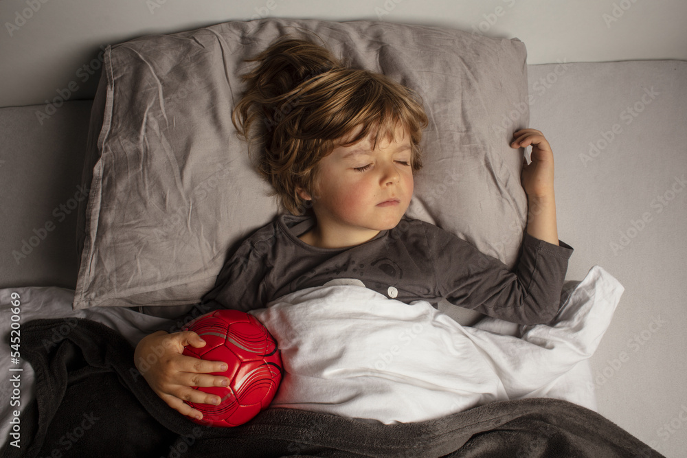 Healthy child, sweetest blonde toddler boy sleeping in a football ball ...