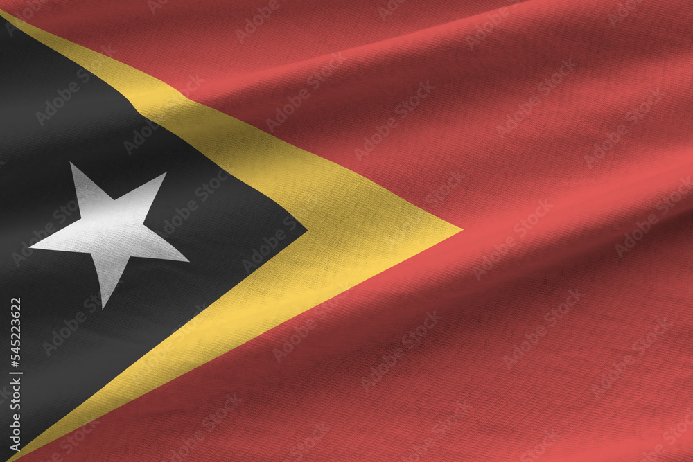 Timor Leste flag with big folds waving close up under the studio light ...