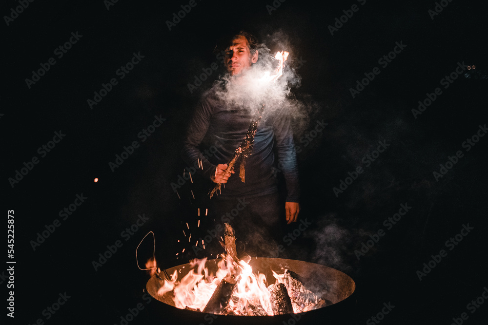 bonfire burning inside a large metal container and caucasian boy ...