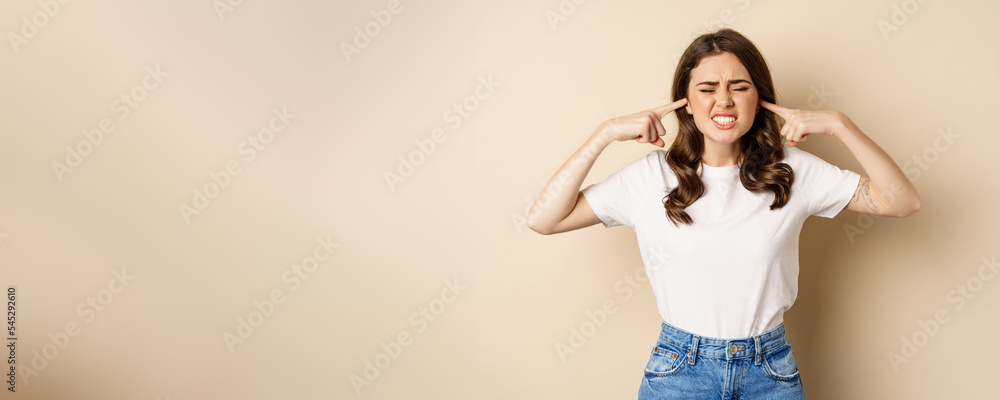 Annoyed young woman shut ears from loud noise, feeling discomfort and ...