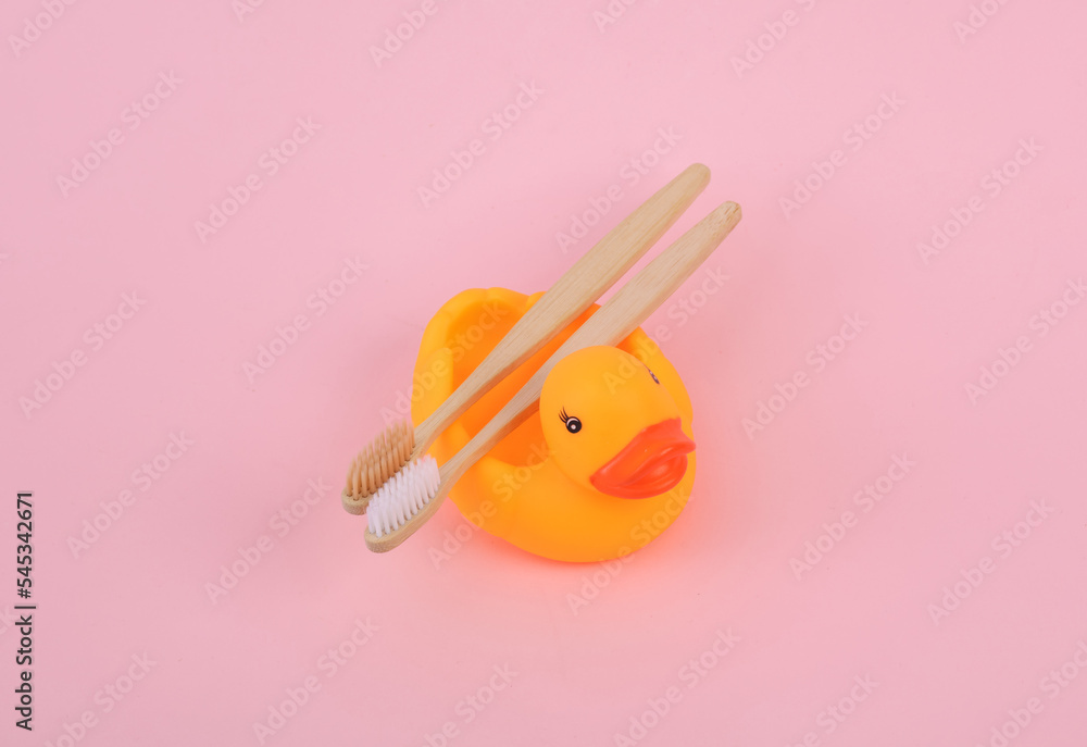 Dental care concept. Eco toothbrushes with baby rubber duck on a pink ...