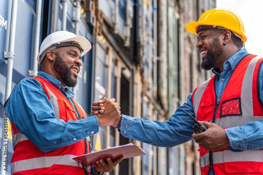 Two black african male professional engineers shake and grab hands ...