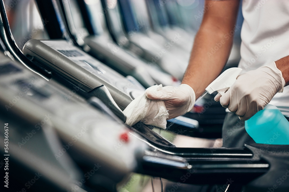 Cleaning, treadmill and sanitizing equipment in gym for bacteria, germs ...