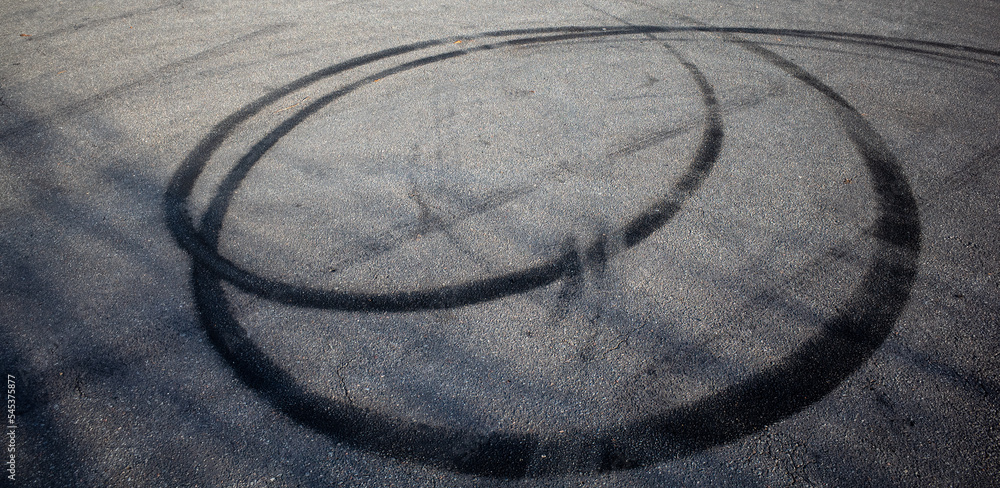 skid marks on a road surface. Circular tire marks left by drivers doing ...
