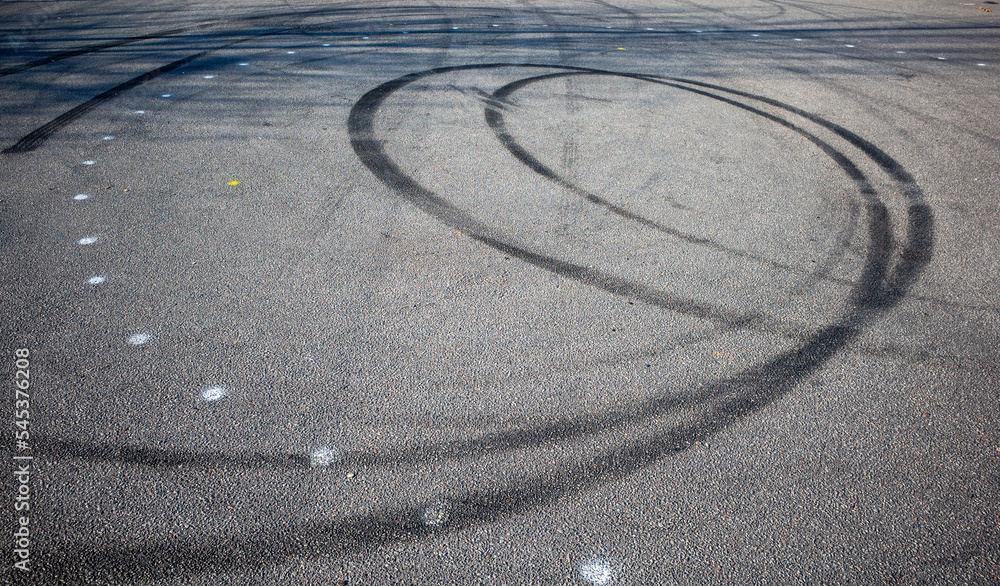 skid marks on a road surface. Circular tire marks left by drivers doing ...