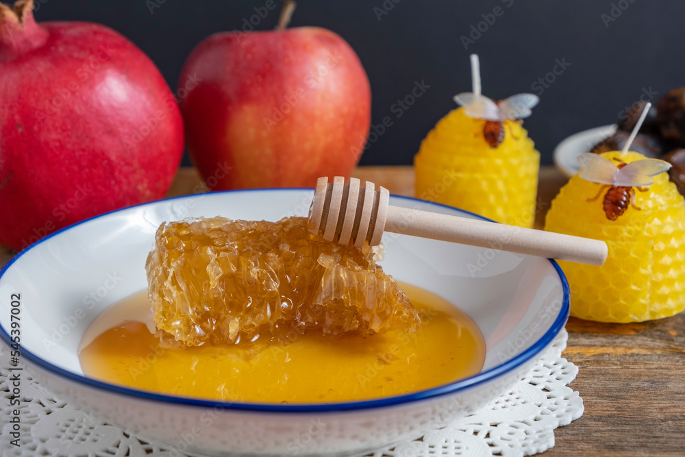 Honey stick on honeycomb on the background of traditional Rosh Hashanah ...