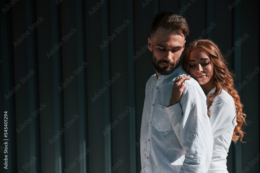 Embracing each other. Beautiful young couple is standing together ...