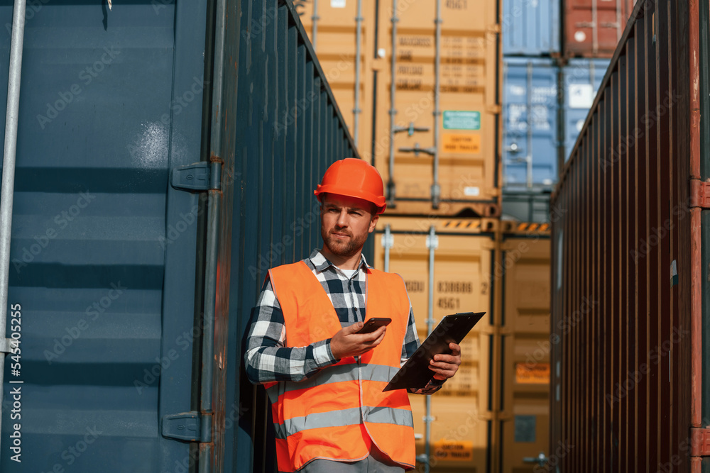 Using phone and holding tablet. Male worker is on the location with ...