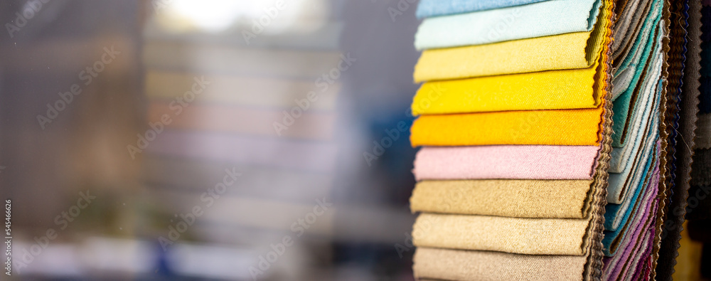 Fabric swatches in different colors are stacked for selection. A ...