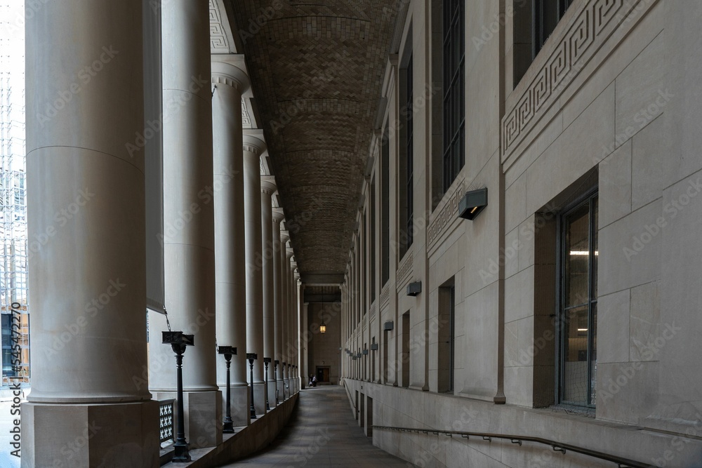 Diminishing perspective of exterior hallway with columns on one side ...