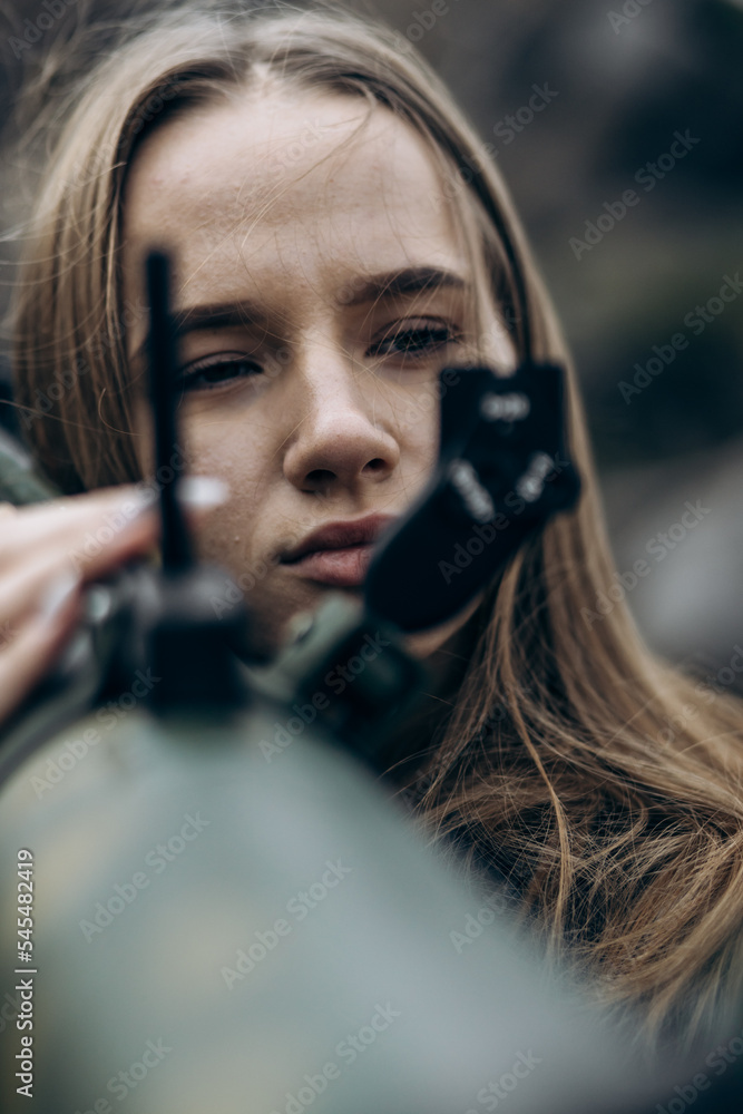 Guy and girl in military with bazooka and machine guns pose for camera ...