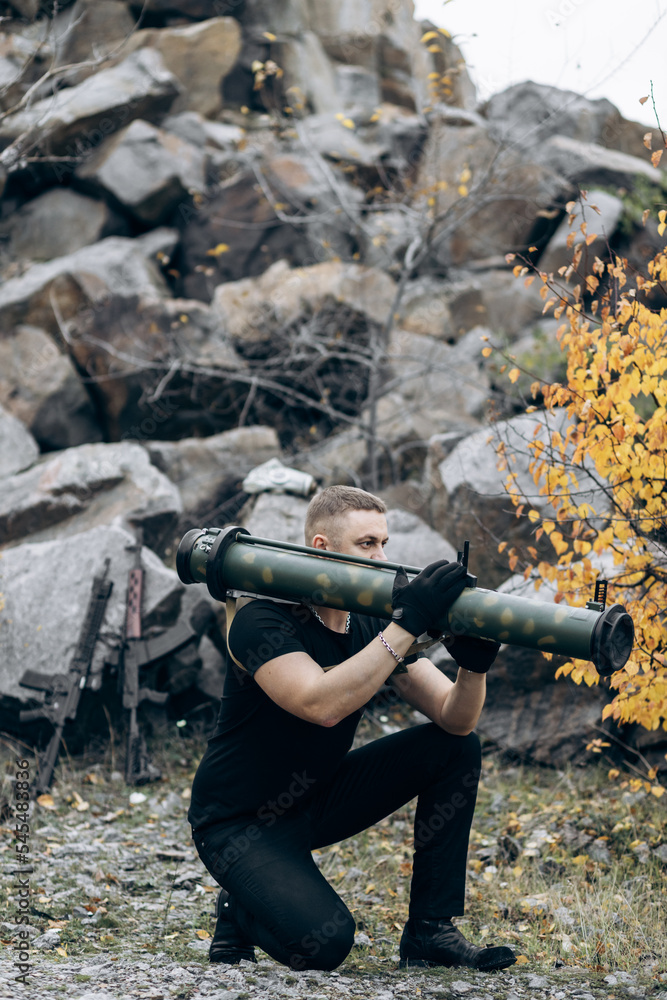 Guy and girl in military with bazooka and machine guns pose for camera ...