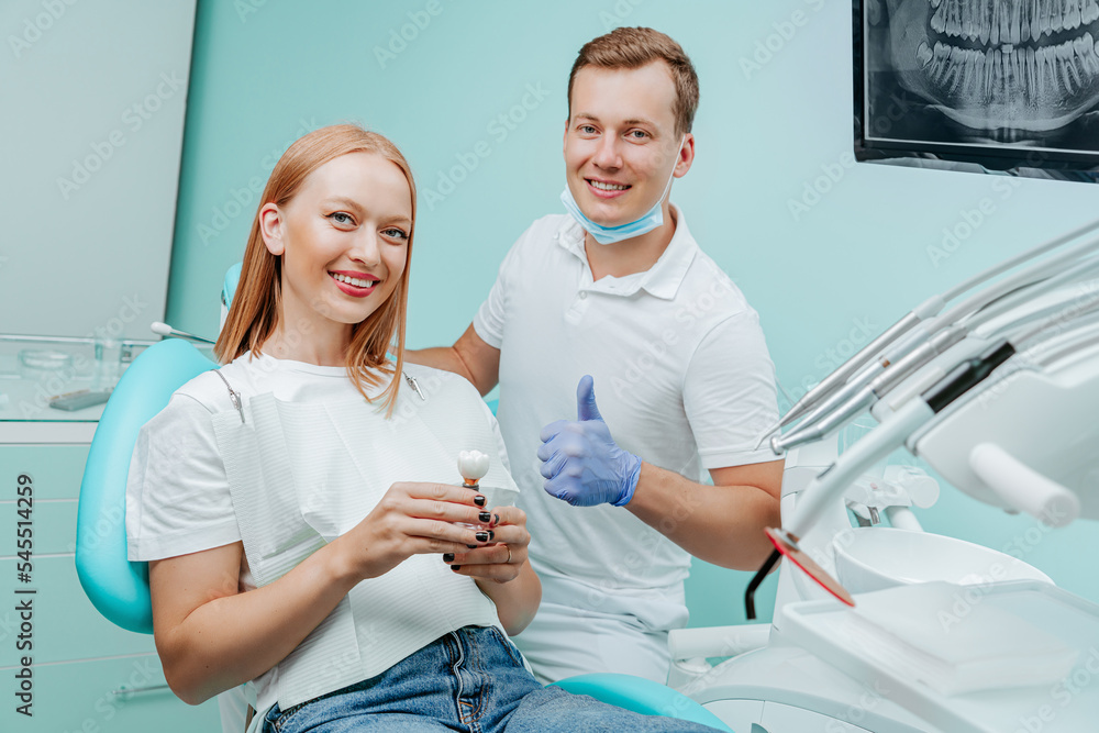 Doctor dentist and young woman patient smiling in dental clinic with ...
