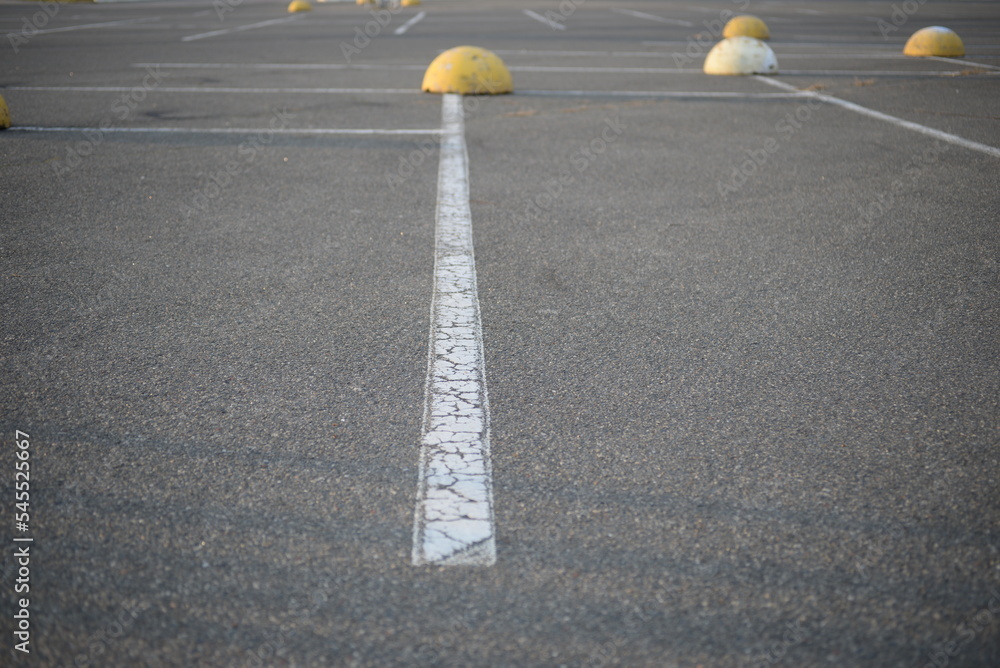 concrete traffic limiters, concrete tokens painted white, parking space ...