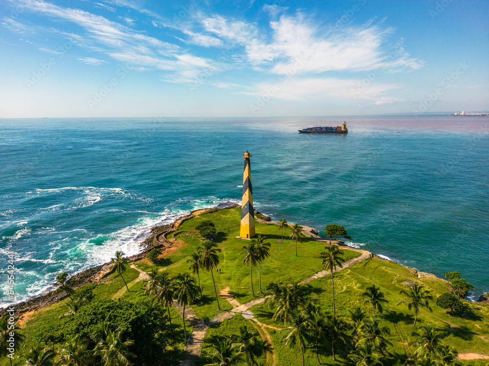 Aerial view of lighthouse Faro San Souci and cargo container ship on ...