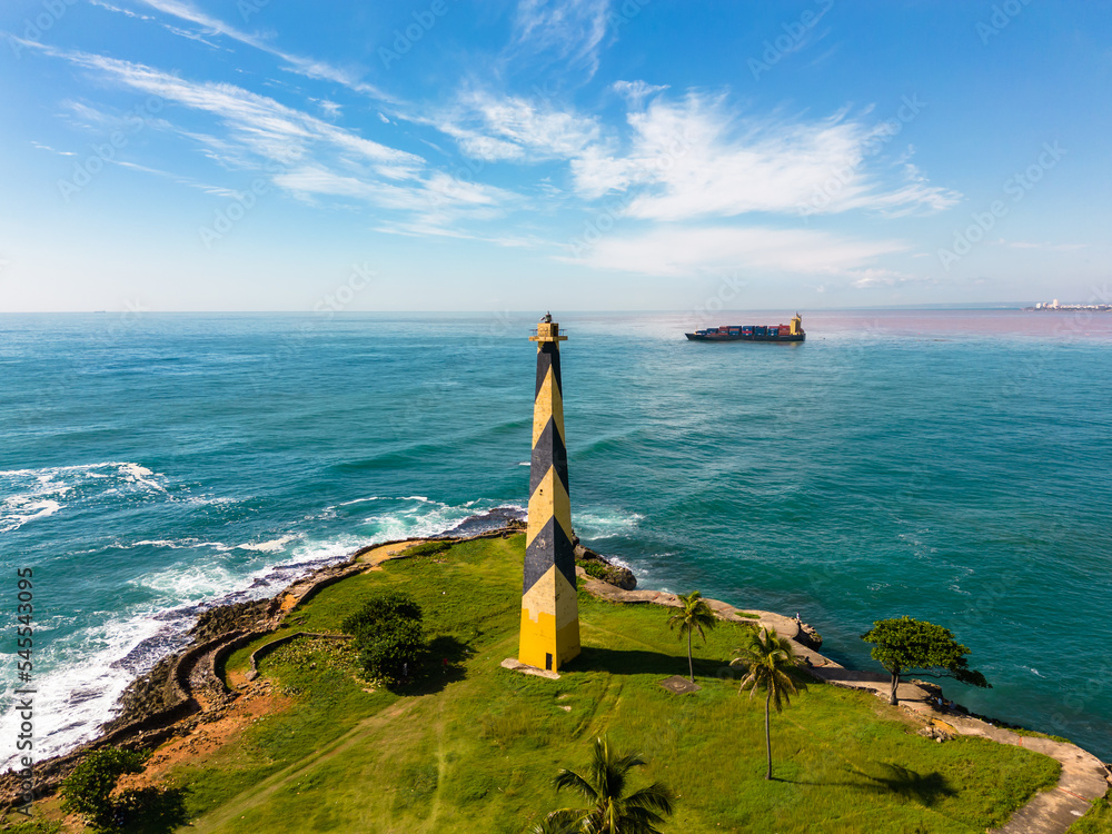 Aerial view of lighthouse Faro San Souci and cargo container ship on ...