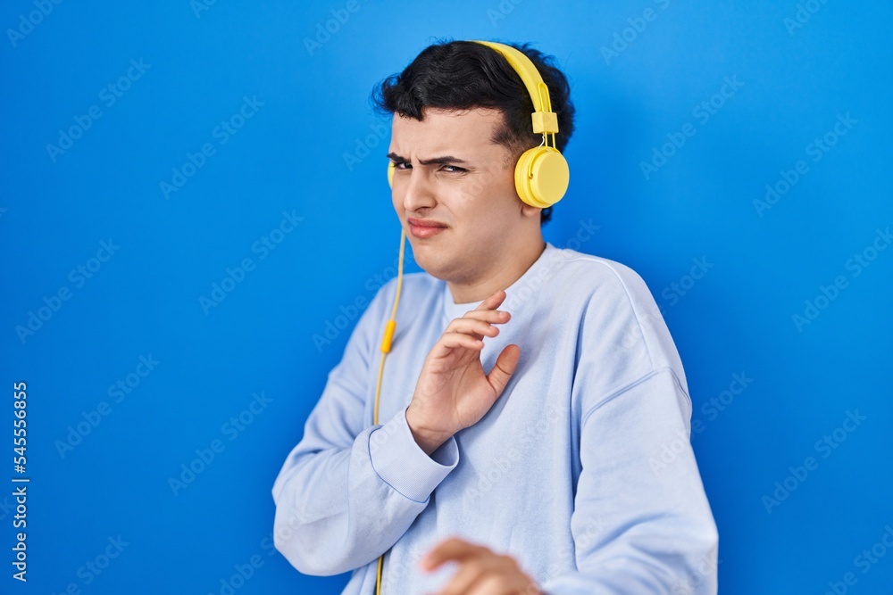 Photo & Art Print Non binary person listening to music using headphones ...