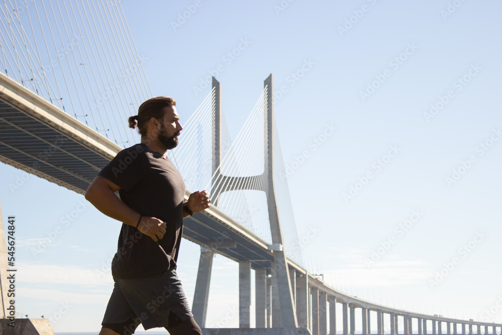 Side view of man with disability running outdoors. Happy athlete in ...
