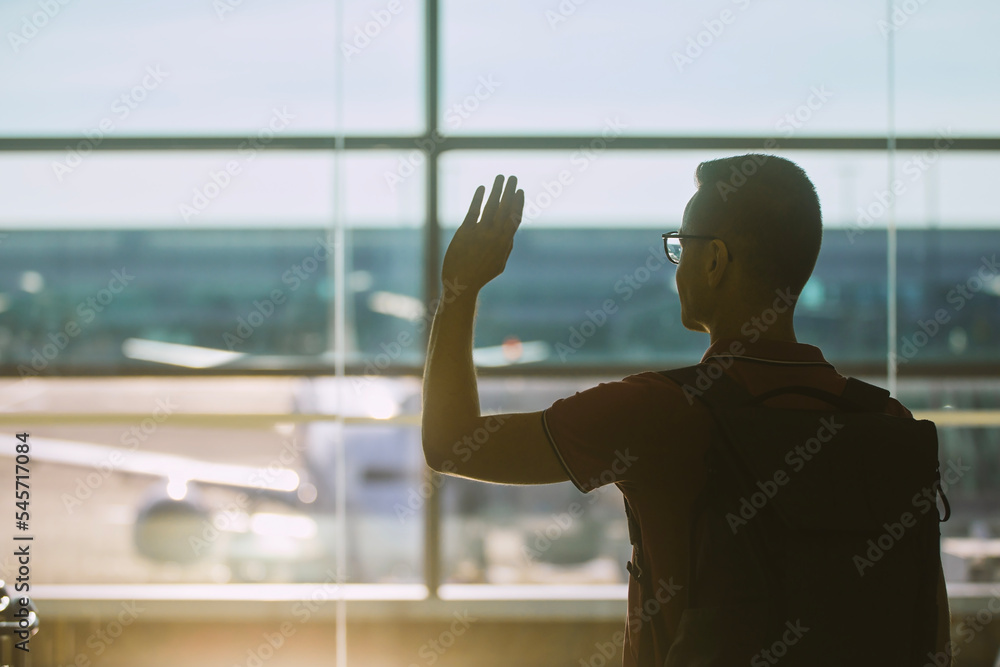Saying goodbye at airport. Leaving man is waving his hand.. Stock Photo ...
