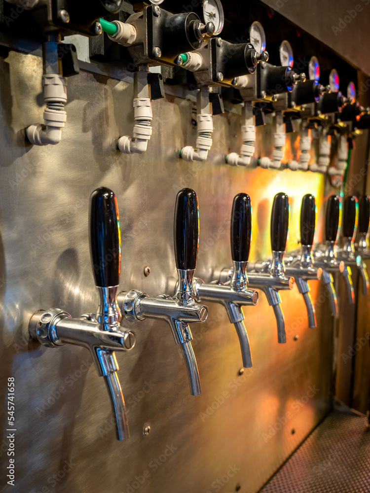 Row of beer tap lines for cold draft beer in pub and restaurant. Craft ...
